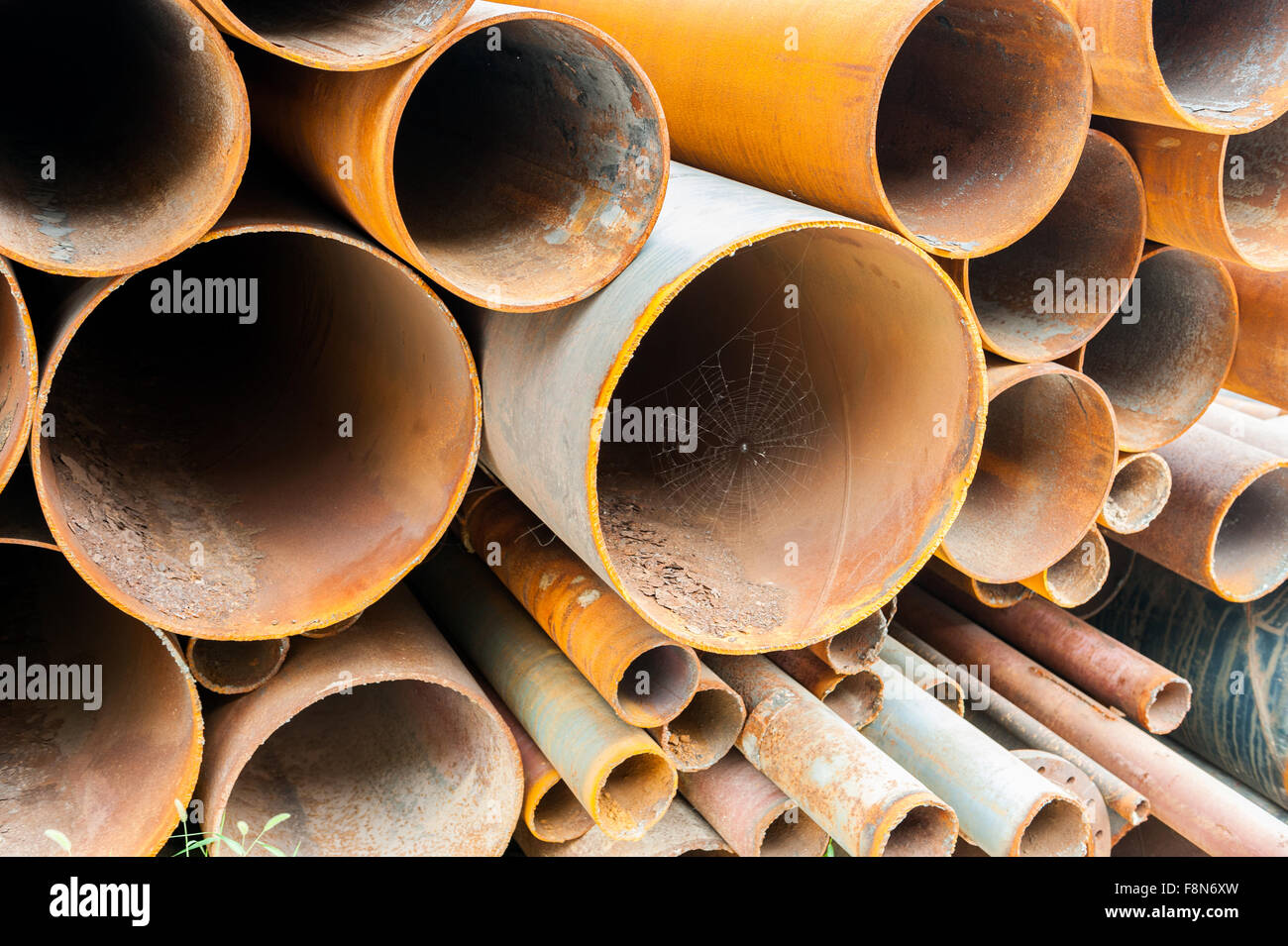 looking through a stack of industrial rusty metal tubes Stock Photo - Alamy