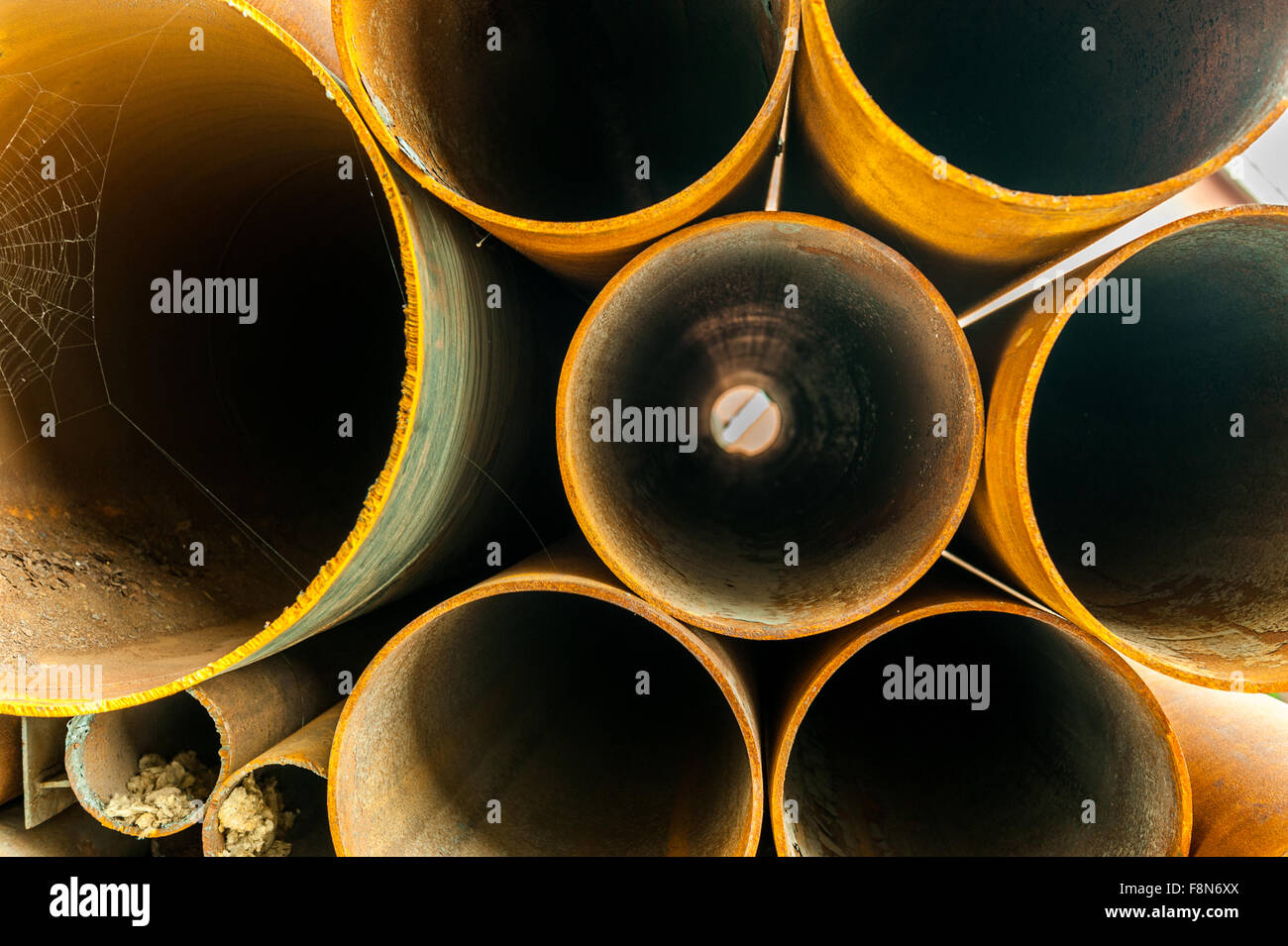 looking through a stack of industrial rusty metal tubes Stock Photo - Alamy