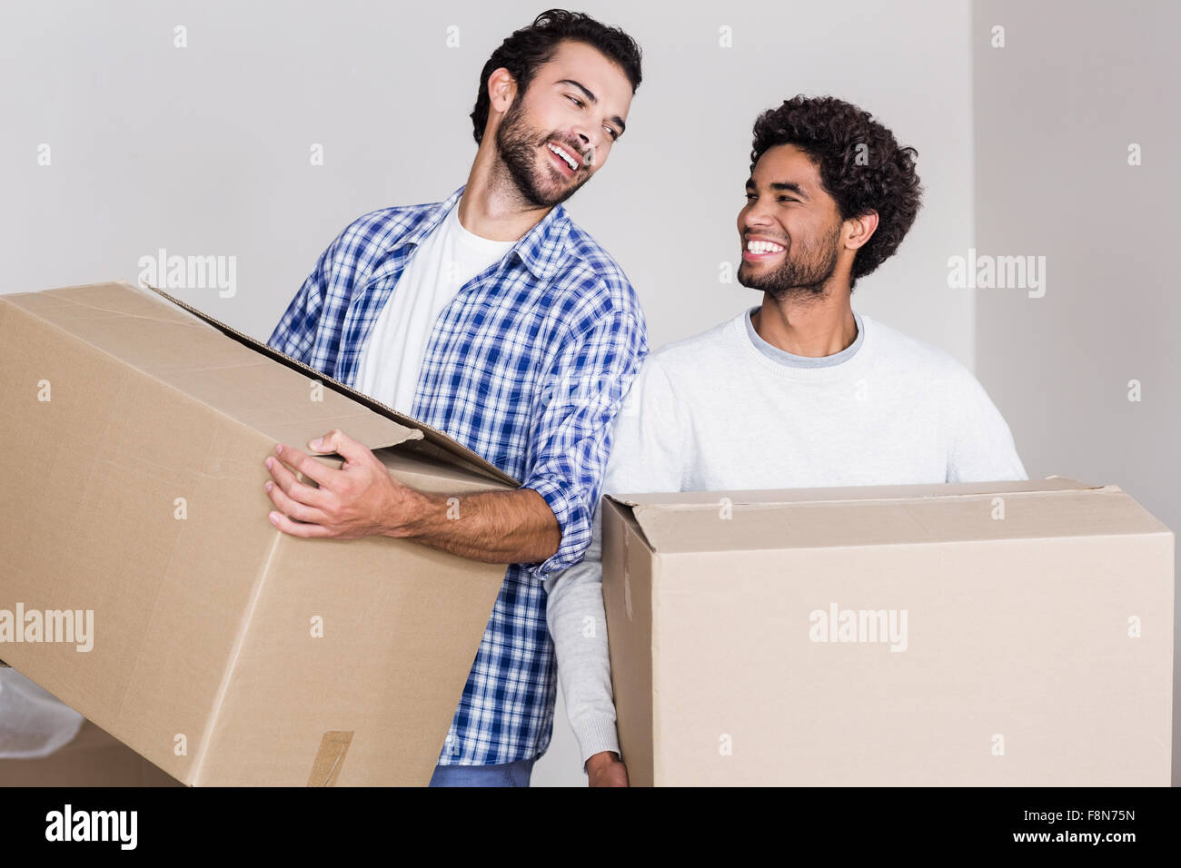 Happy gay couple holding big boxes Stock Photo - Alamy