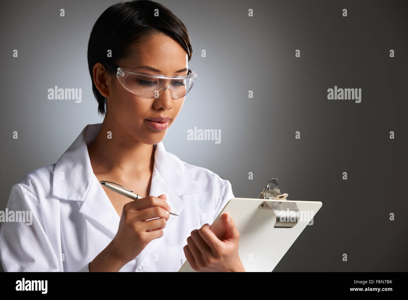 Female Scientist Writing On Clipboard Stock Photo - Alamy