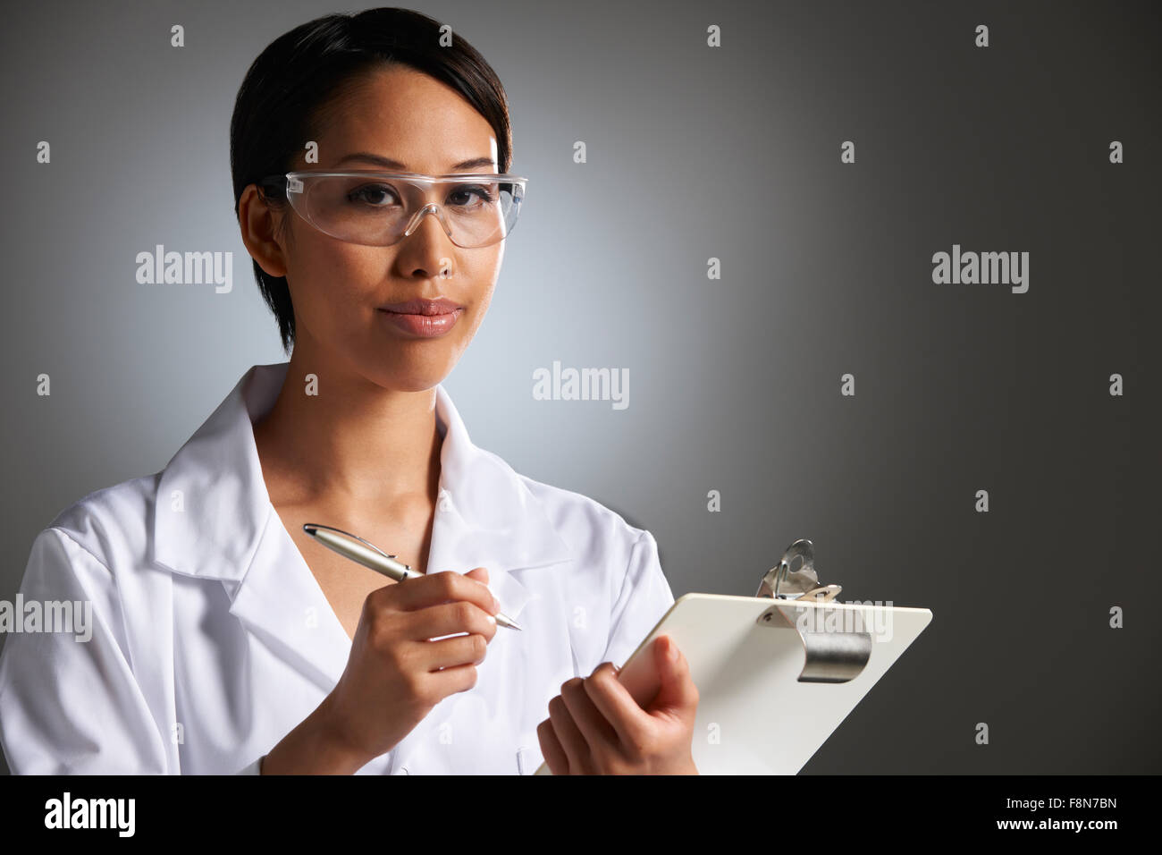 Female Scientist Writing On Clipboard Stock Photo - Alamy