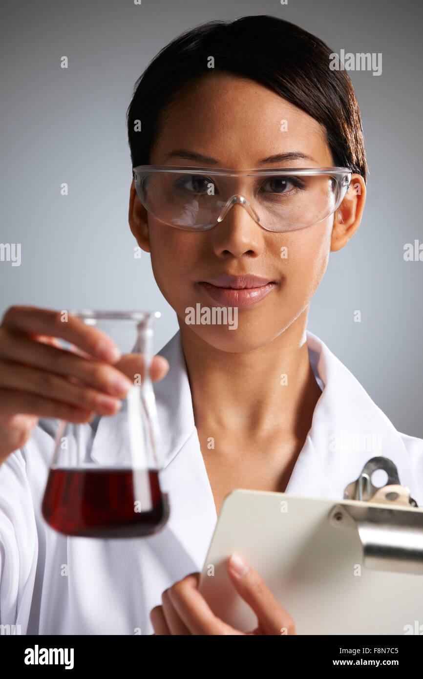 Scientist With Clipboard Examining Beaker Stock Photo - Alamy