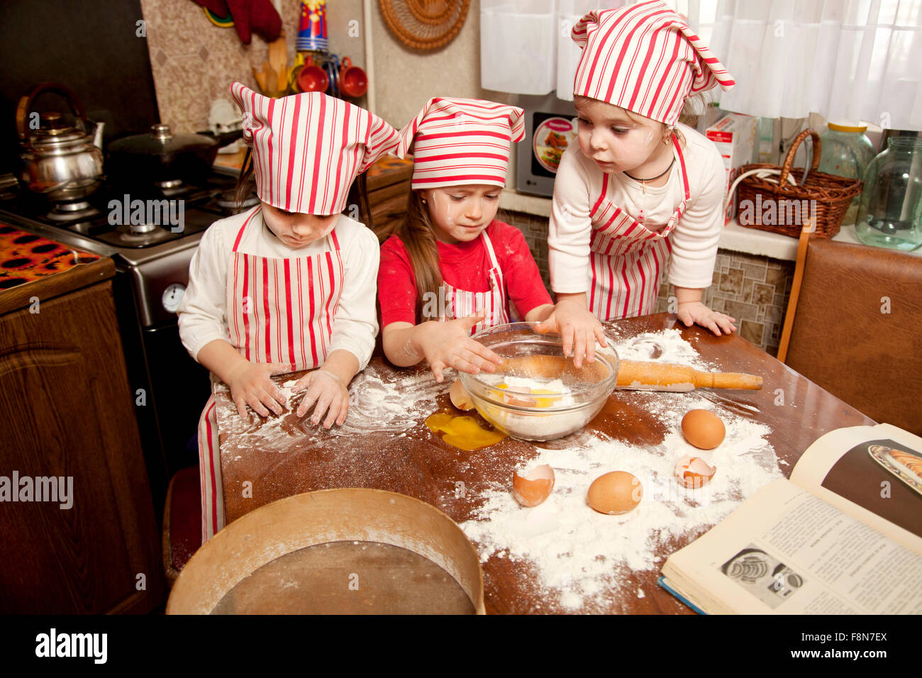 Three little chefs enjoying in the kitchen making big mess. Litt Stock ...