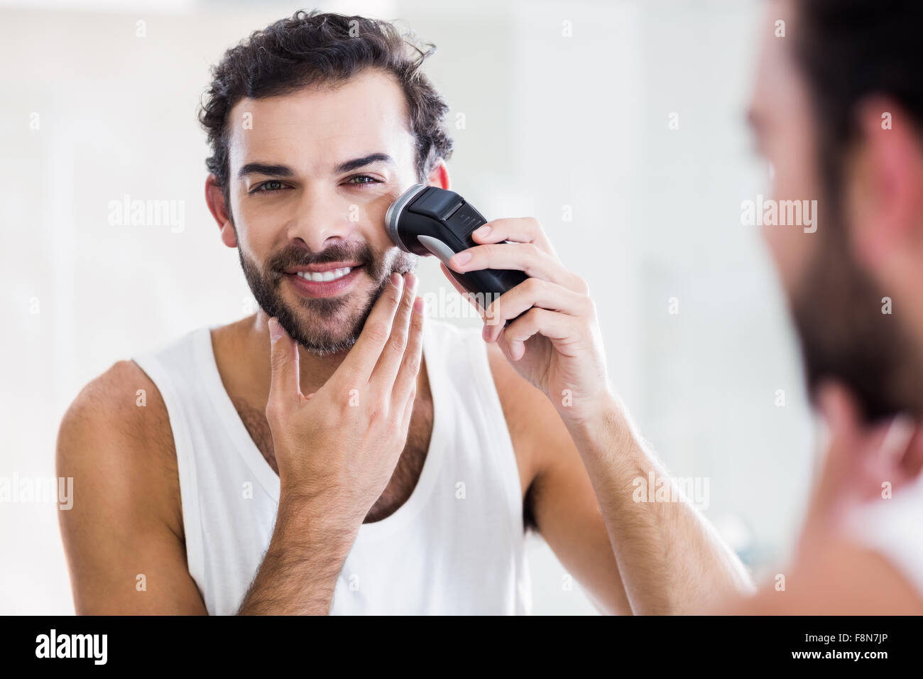 Reflection of smiling man shaving with electric razor Stock Photo - Alamy