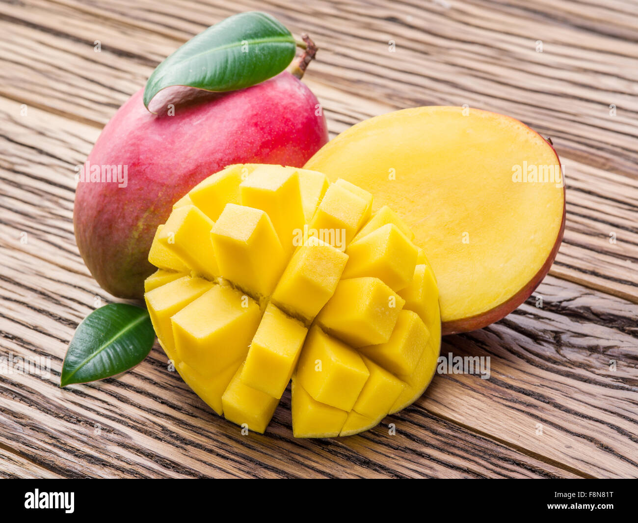 Mango fruit and mango cubes on the wooden table Stock Photo - Alamy