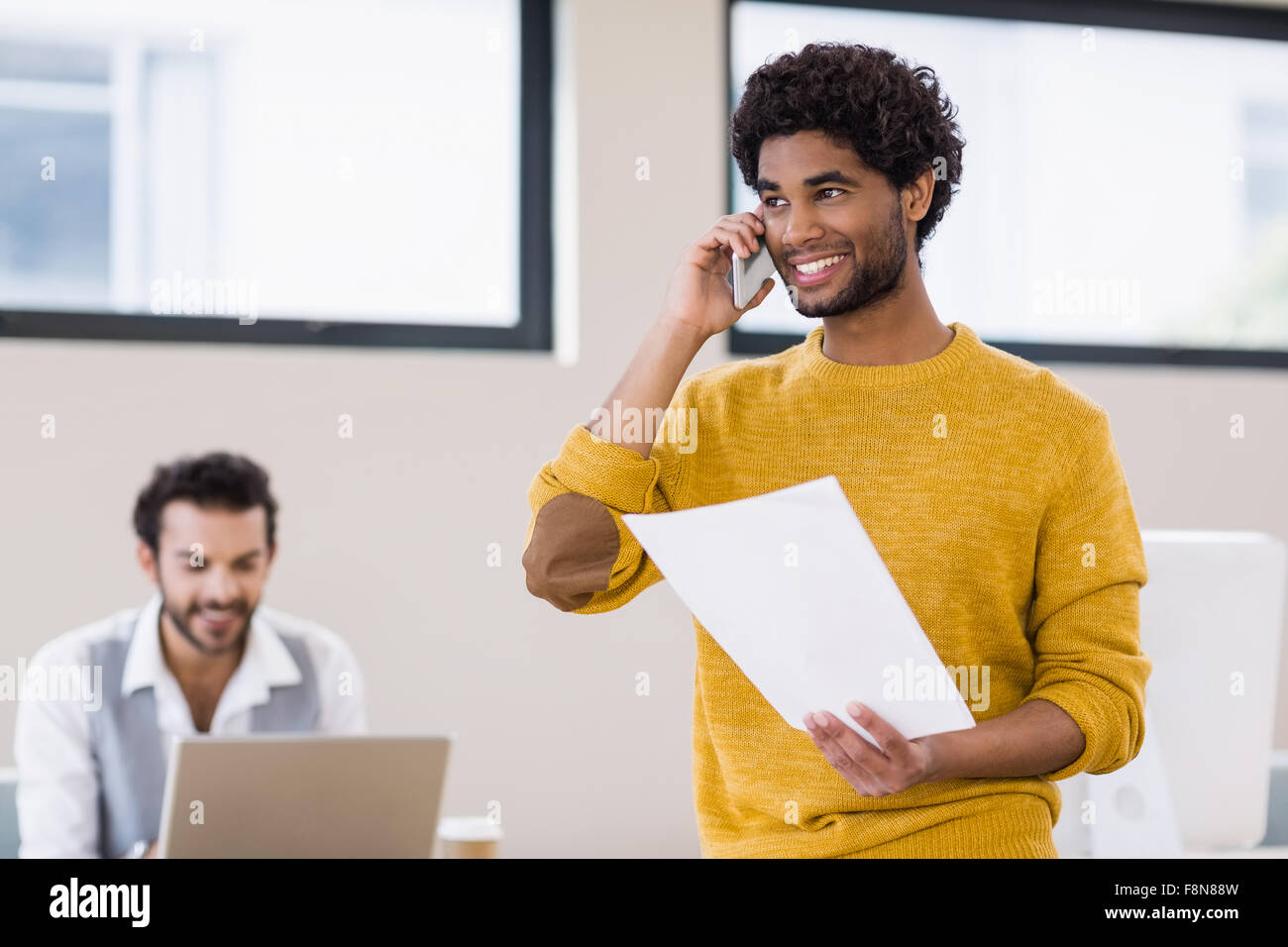 Smiling man holding document in phone call Stock Photo - Alamy