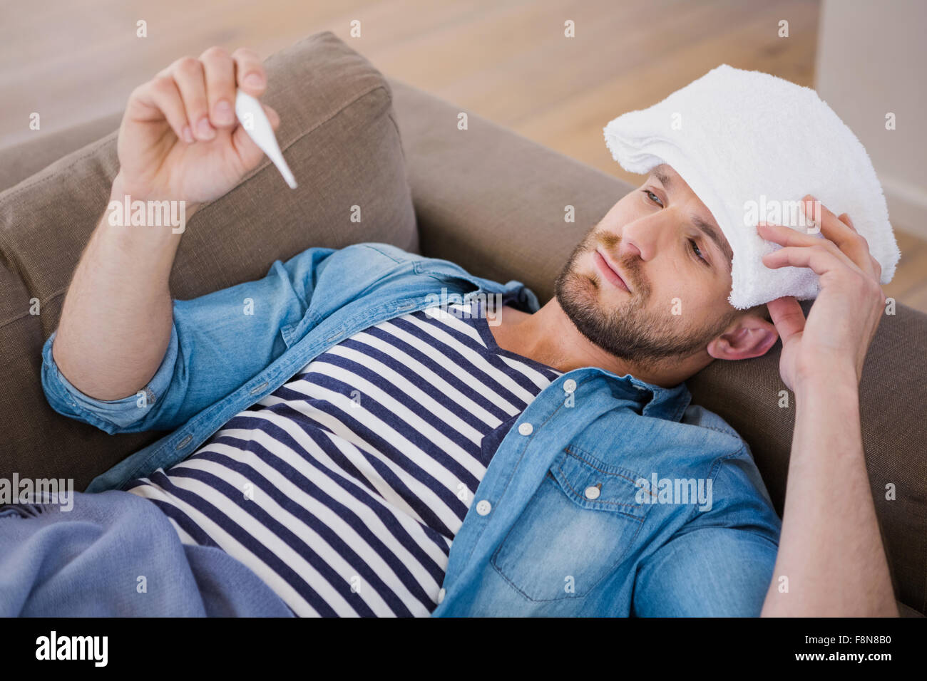Sick man checking his temperature Stock Photo - Alamy