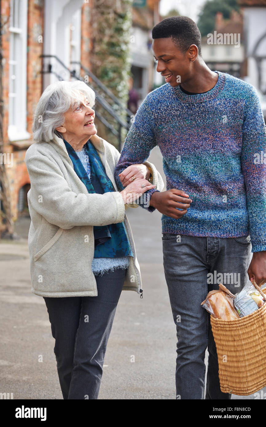 Teenage Boy Helping Senior Woman To Carry Shopping Stock Photo - Alamy