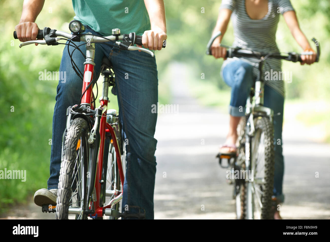 Young Couple Cycling Along Country Road Stock Photo - Alamy