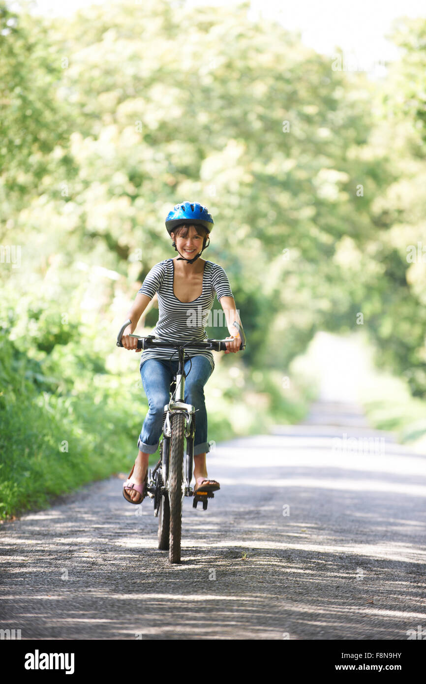 Young Woman Cycling On Country Road Stock Photo - Alamy