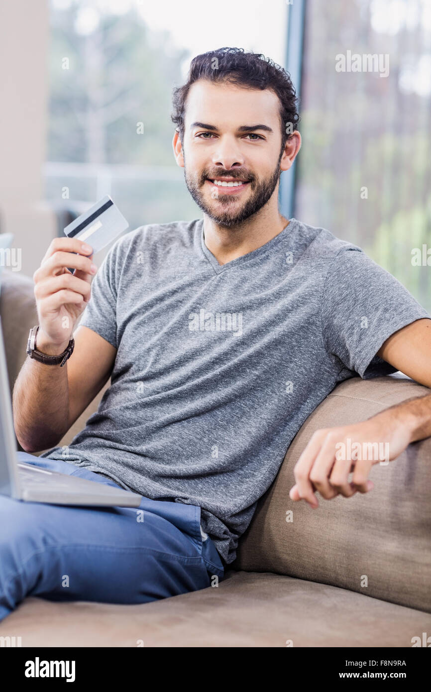 Smiling man using laptop and holding credit card Stock Photo - Alamy Smiling man using laptop and holding credit card Stock Photo - Alamy