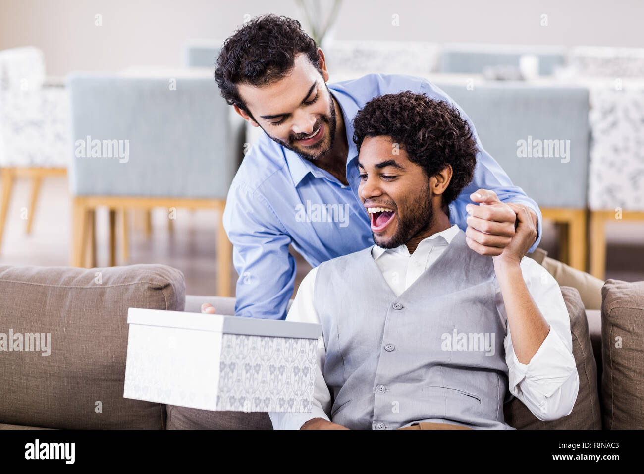 Handsome man giving gift to his boyfriend Stock Photo - Alamy
