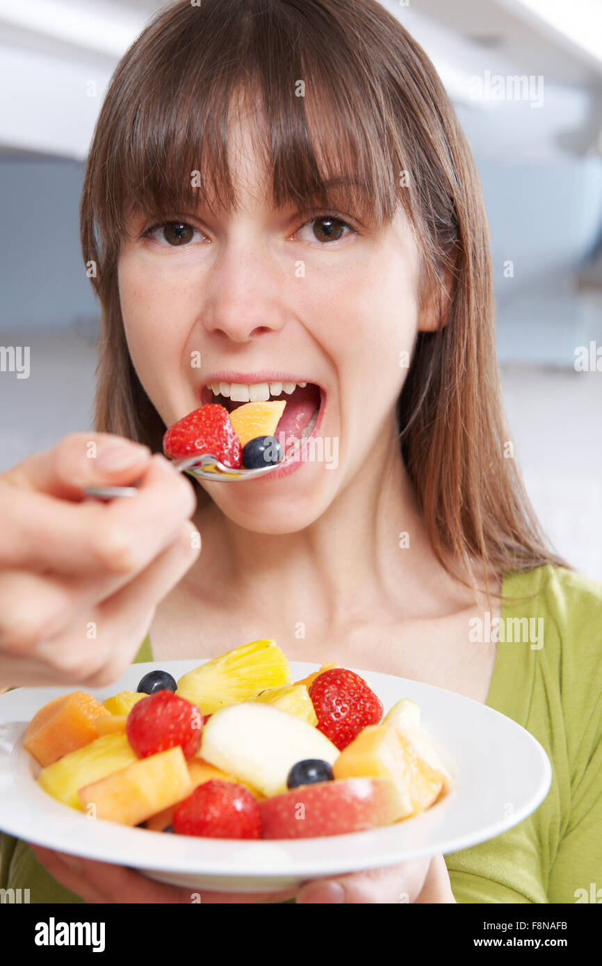 Young Woman Eating Bowl Of Fresh Fruit Stock Photo - Alamy
