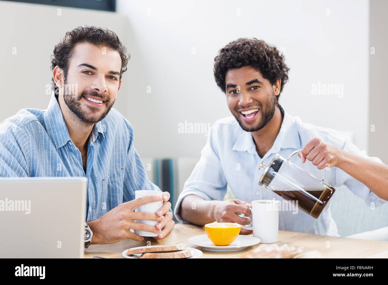Happy gay couple having breakfast Stock Photo - Alamy