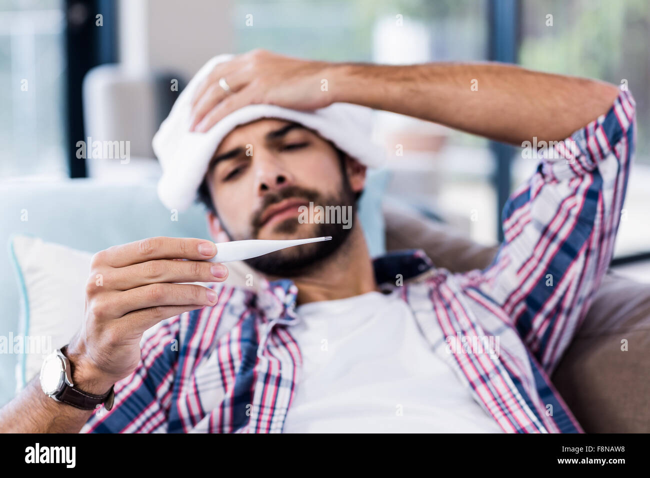 Sick man checking temperature Stock Photo - Alamy