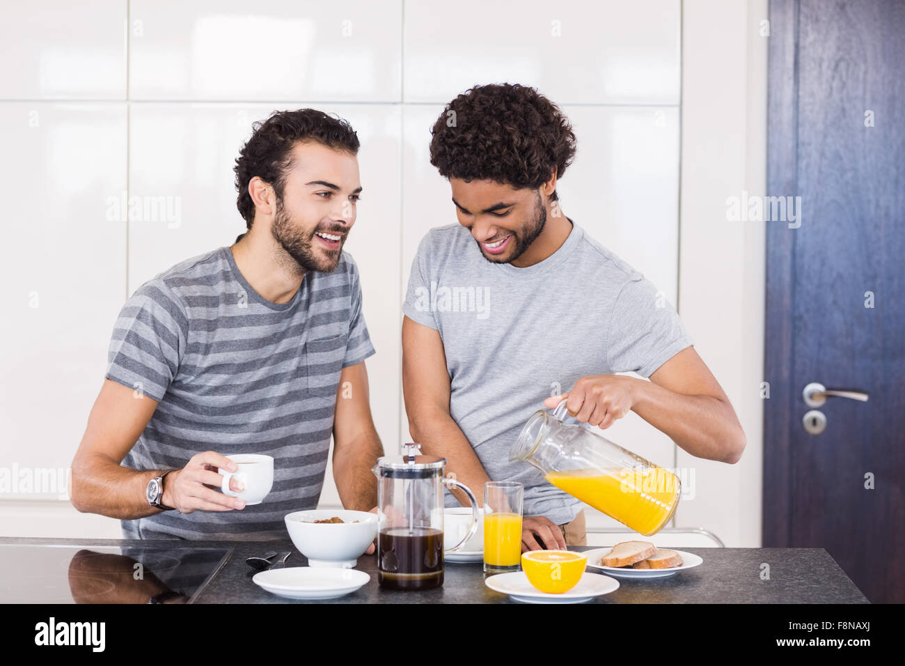Happy gay couple having breakfast and talking Stock Photo - Alamy
