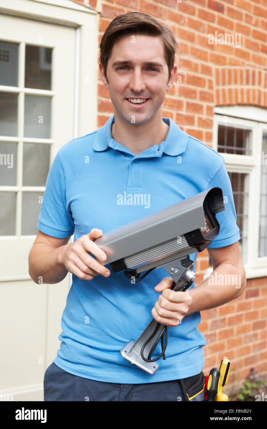 Man Fitting Security Camera To House Wall Stock Photo - Alamy