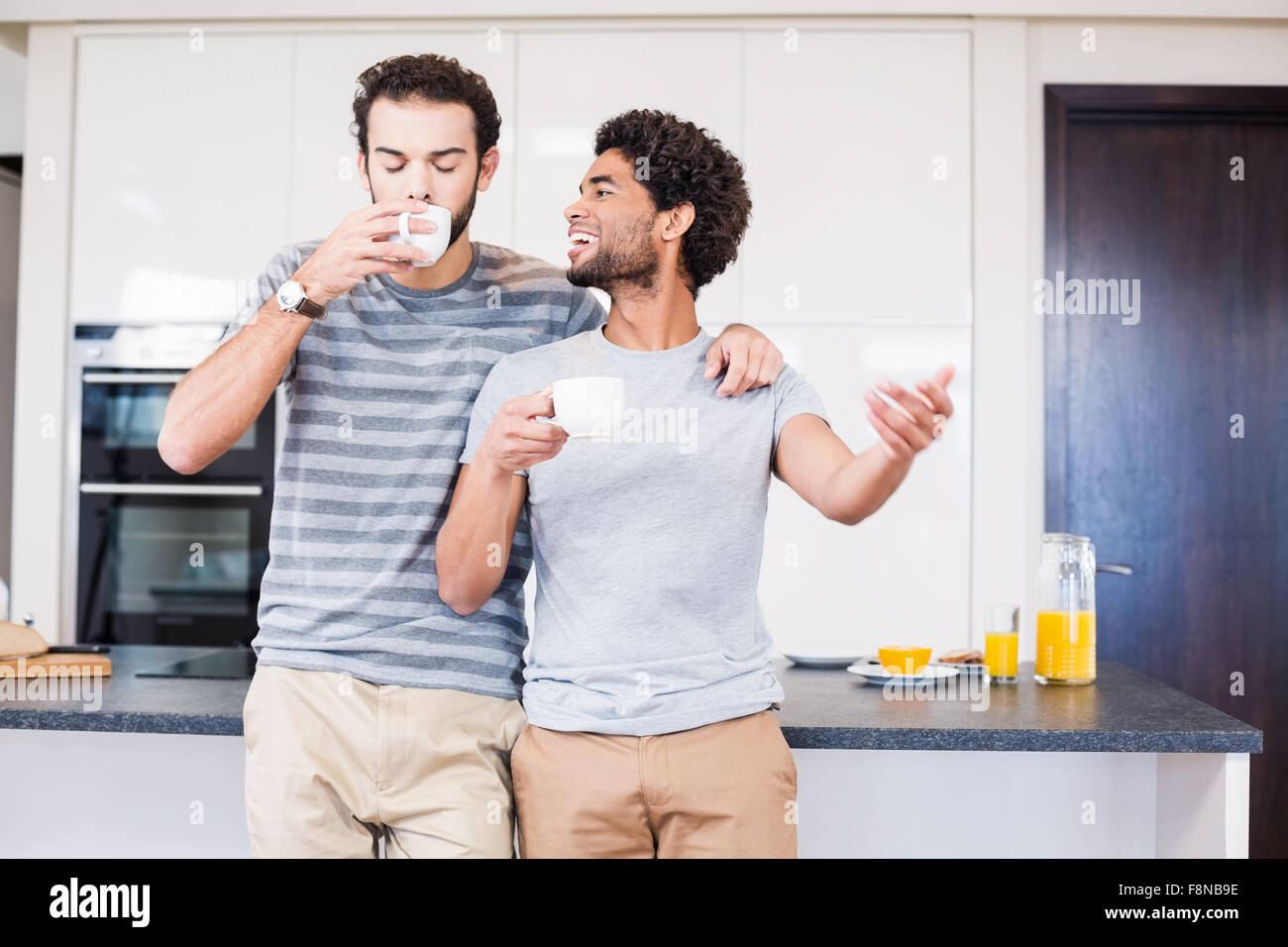 Happy gay couple having breakfast and talking Stock Photo - Alamy