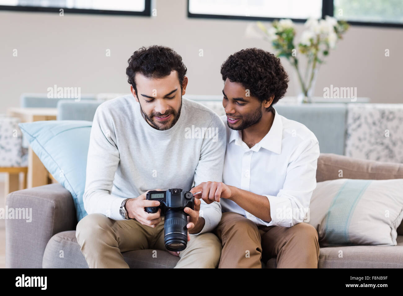 Happy gay couple looking at camera Stock Photo - Alamy