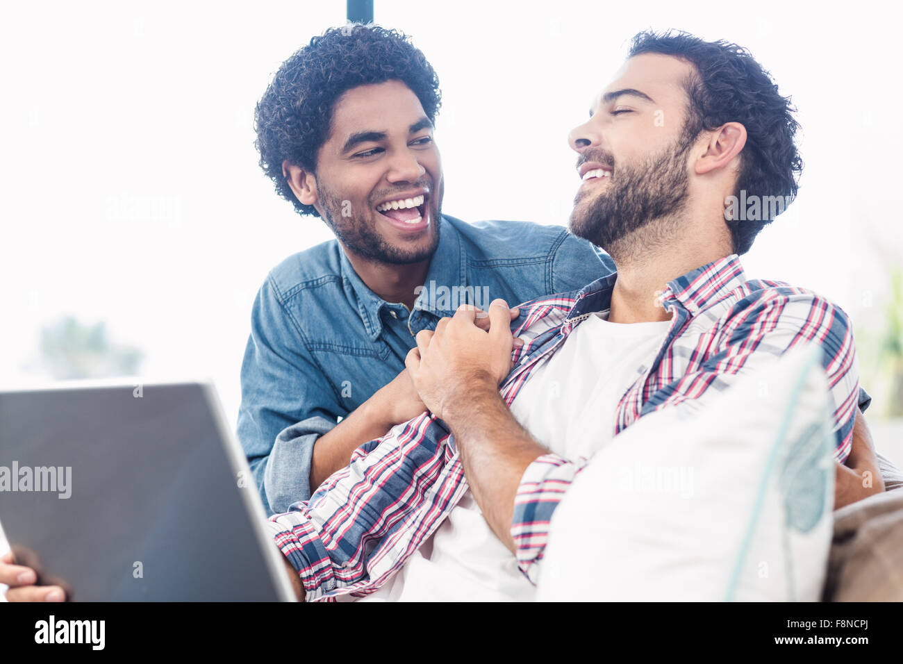 Happy gay couple using laptop Stock Photo - Alamy