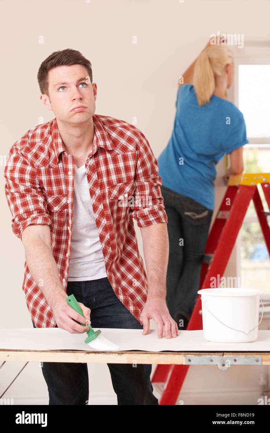 Young Man Fed Up With Decorating Home Stock Photo - Alamy