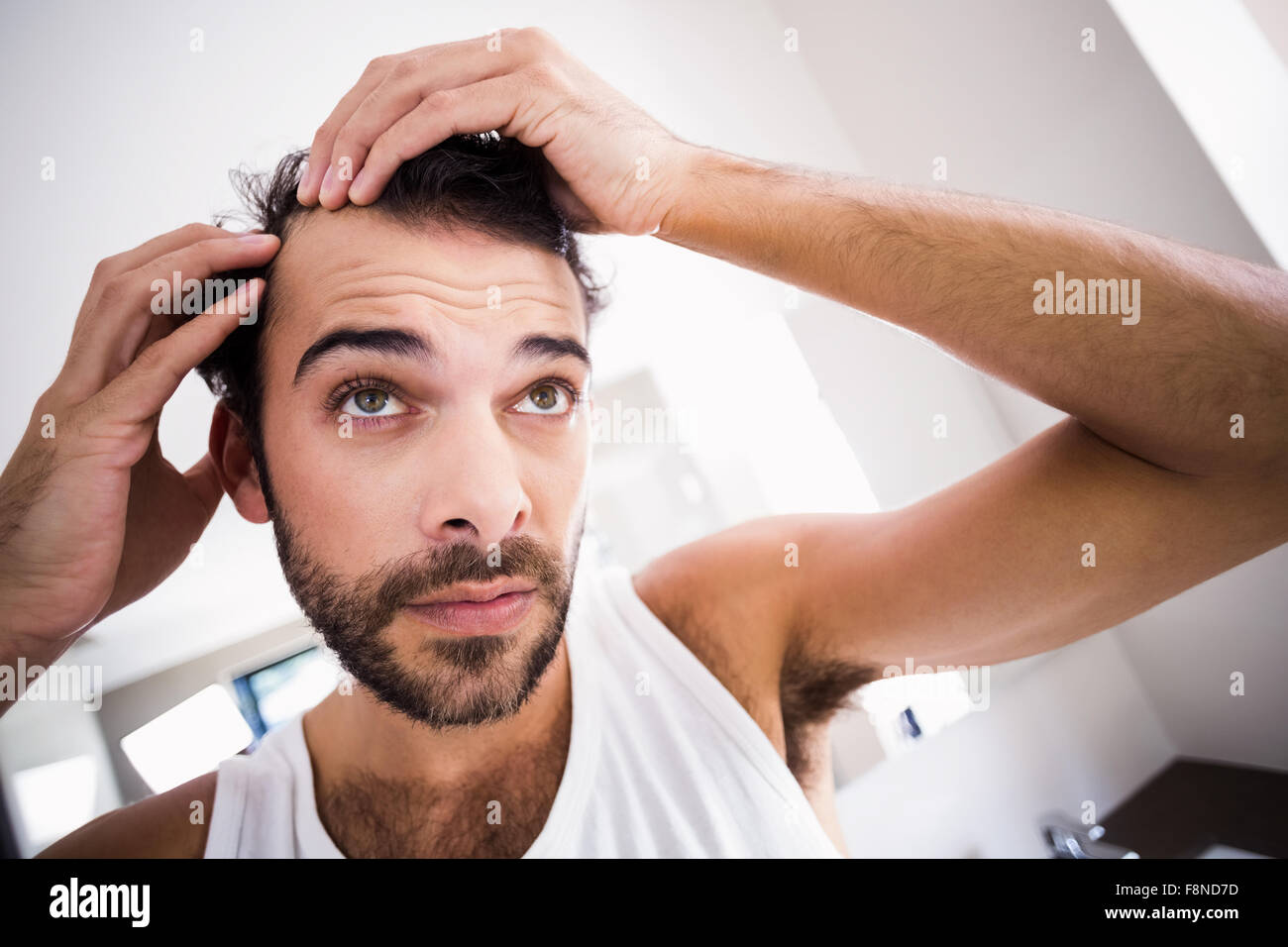 Concentrated man looking at his hair Stock Photo - Alamy