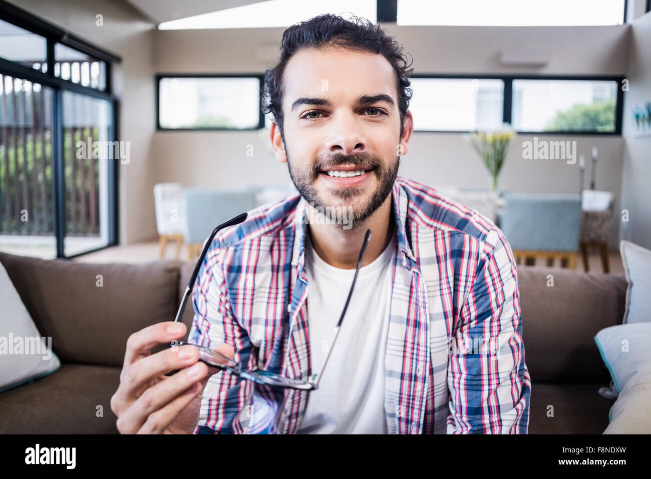 Portrait of smiling man holding glasses Stock Photo - Alamy