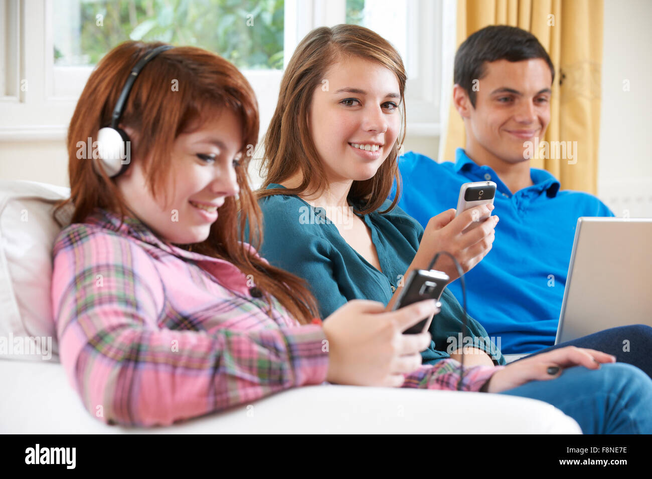 Teenage Friends Using Digital Technology At Home Stock Photo - Alamy