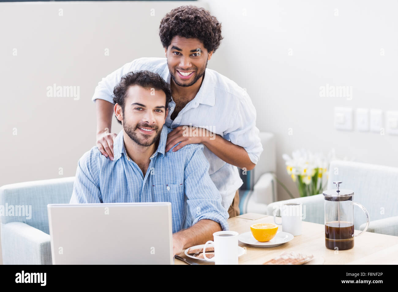 Happy gay couple using laptop Stock Photo - Alamy