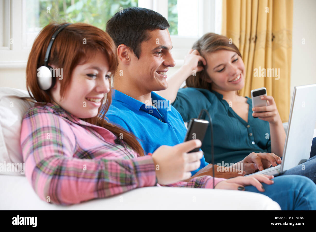 Teenage Friends Using Digital Technology At Home Stock Photo - Alamy
