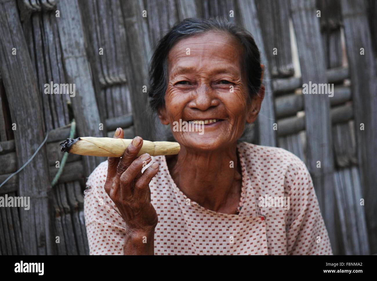 Smiling Asiatic woman smoking a cigar Image taken in a little village ...