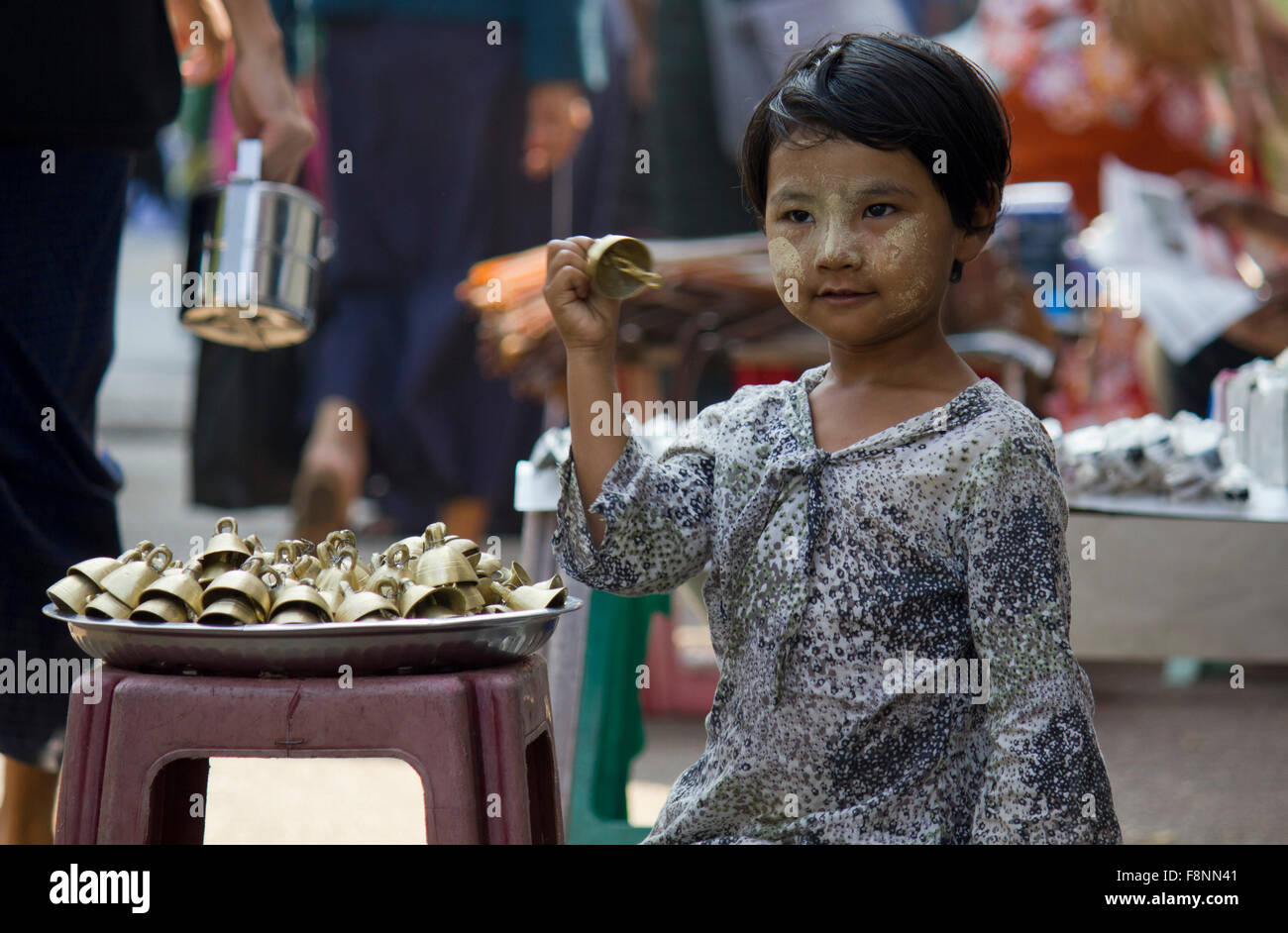 Young Bells seller. A young girl selling bells in the street of Yangoon ...