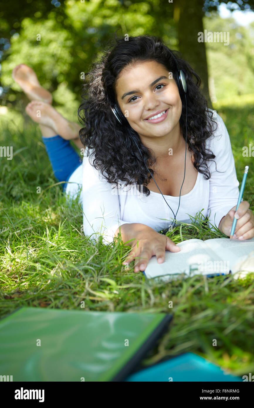 Carefree Student Revising And Listening To Music In Park Stock Photo ...