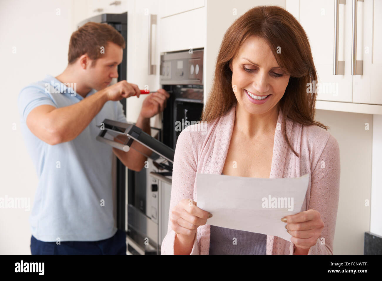 Smiling Woman With Repair Bill Stock Photo - Alamy