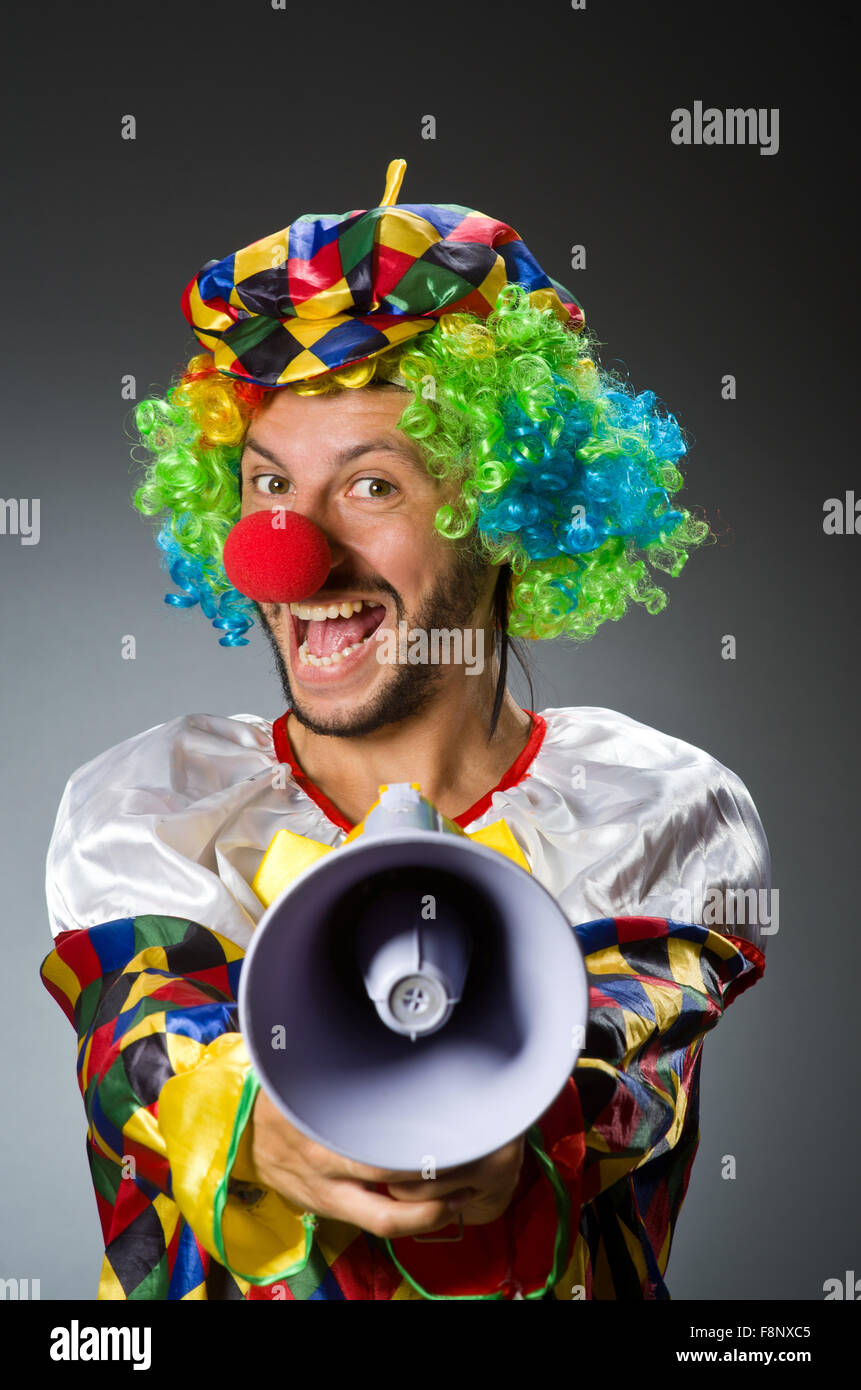Clown with loudspealer against curtain Stock Photo - Alamy
