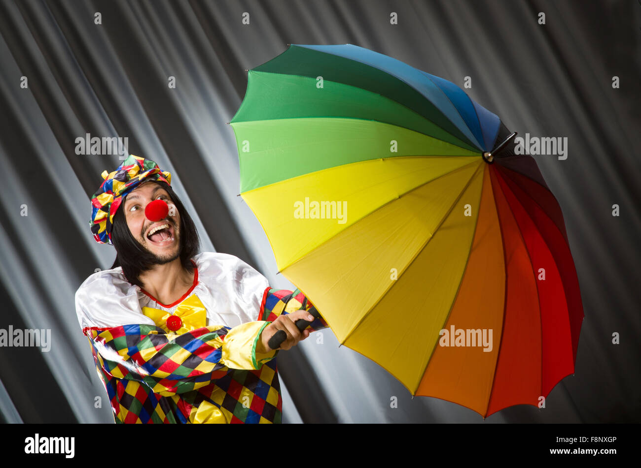 Funny clown with colourful umbrella Stock Photo - Alamy