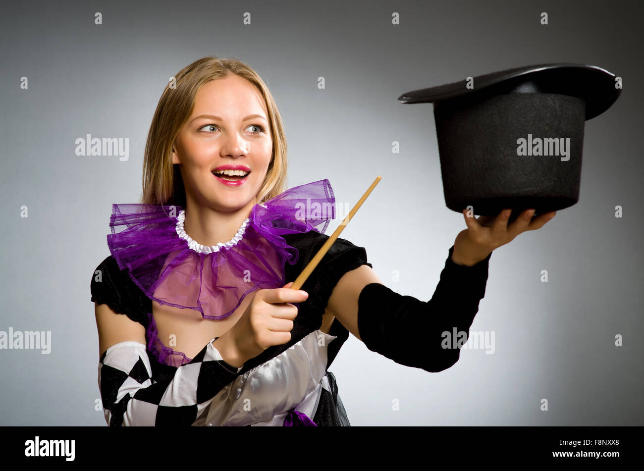 Woman magician doing her tricks with wand Stock Photo - Alamy