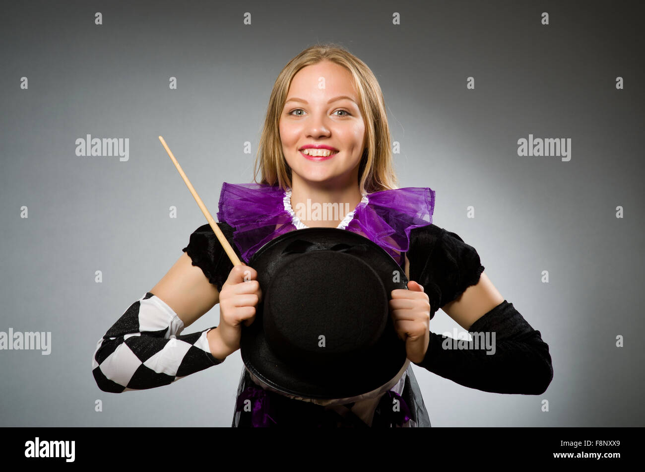 Woman magician doing her tricks with wand Stock Photo - Alamy