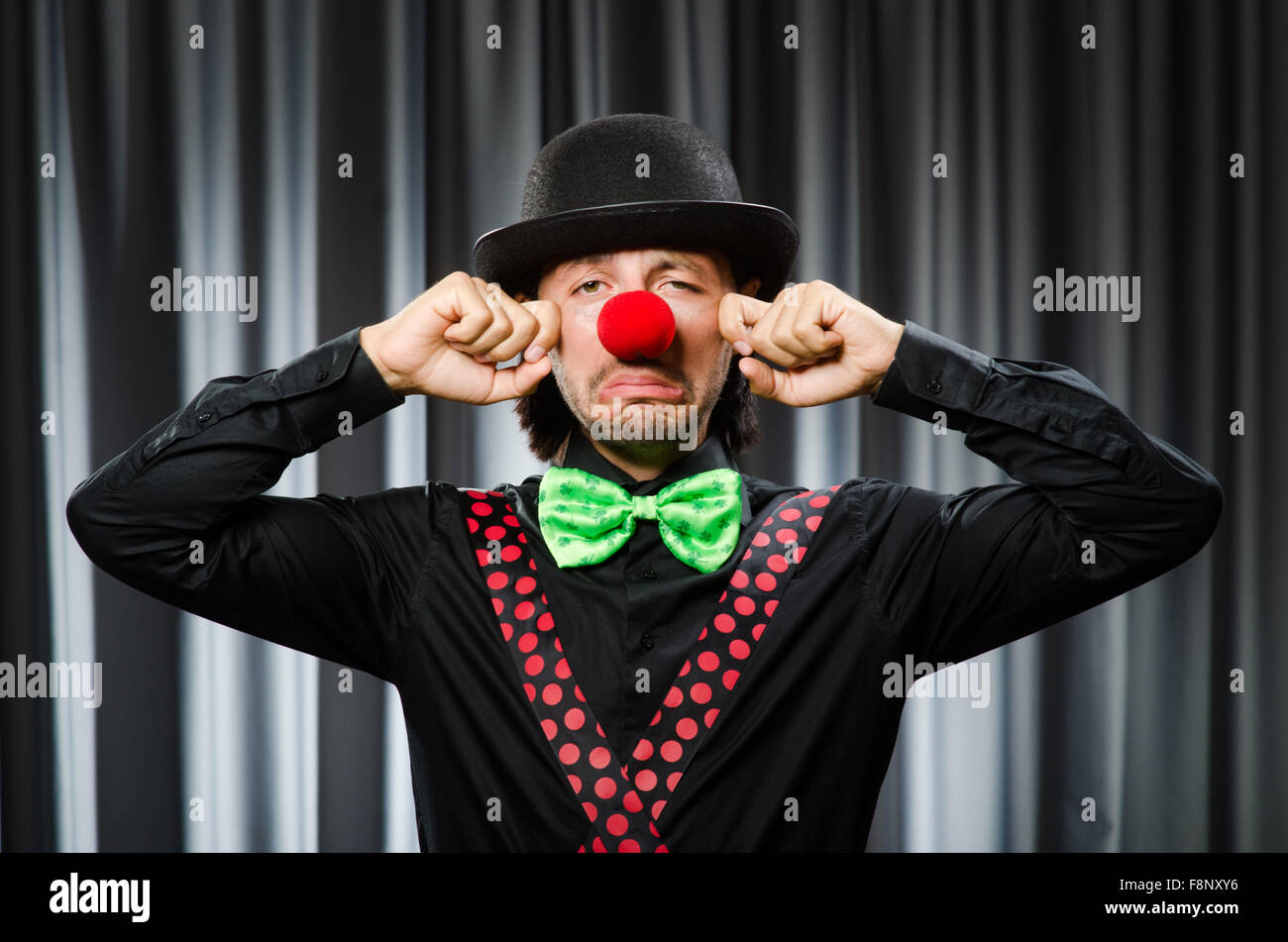 Funny clown in humorous concept against curtain Stock Photo - Alamy