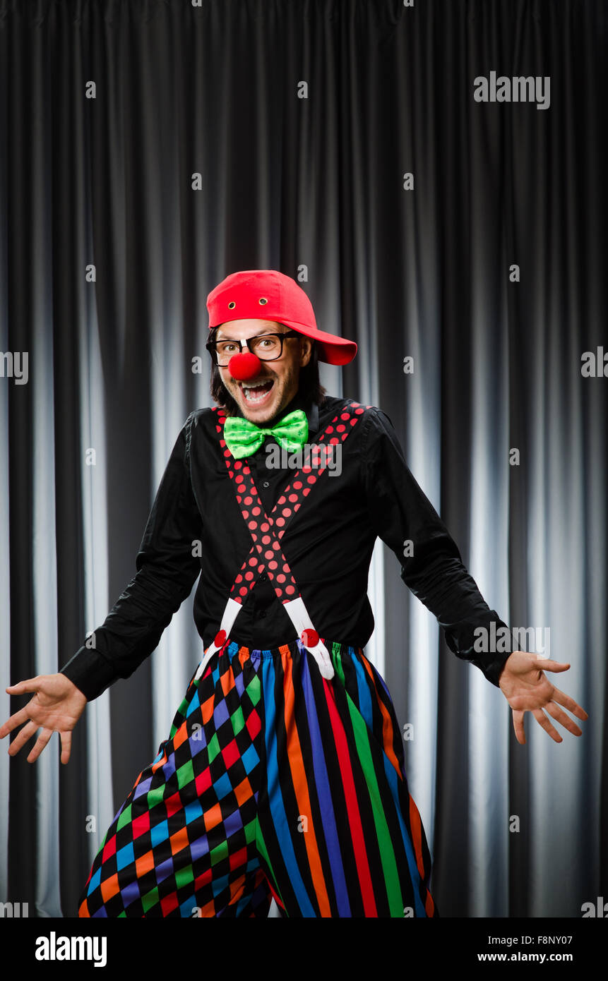 Funny clown in humorous concept against curtain Stock Photo - Alamy