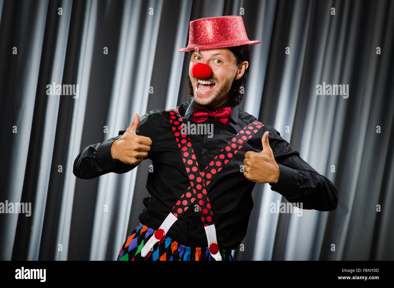 Funny clown in humorous concept against curtain Stock Photo - Alamy