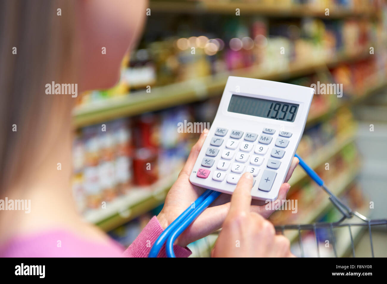 Woman Using Calculator Whilst Shopping In Supermarket Stock Photo - Alamy