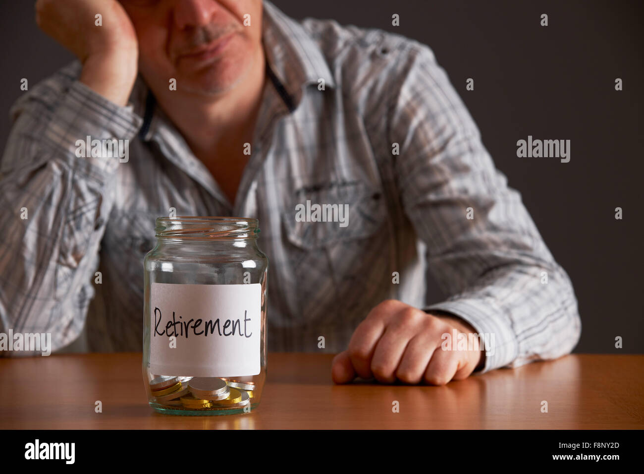 Depressed Man Looking At Empty Jar Labelled Retirement Stock Photo - Alamy