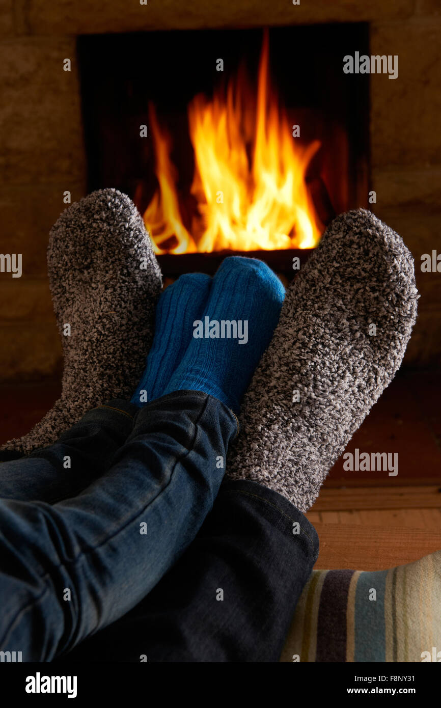 Father And Child Warming Feet By Fire Stock Photo - Alamy