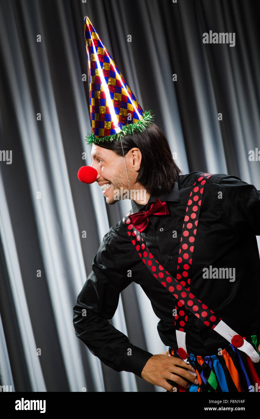 Funny clown in humorous concept against curtain Stock Photo - Alamy