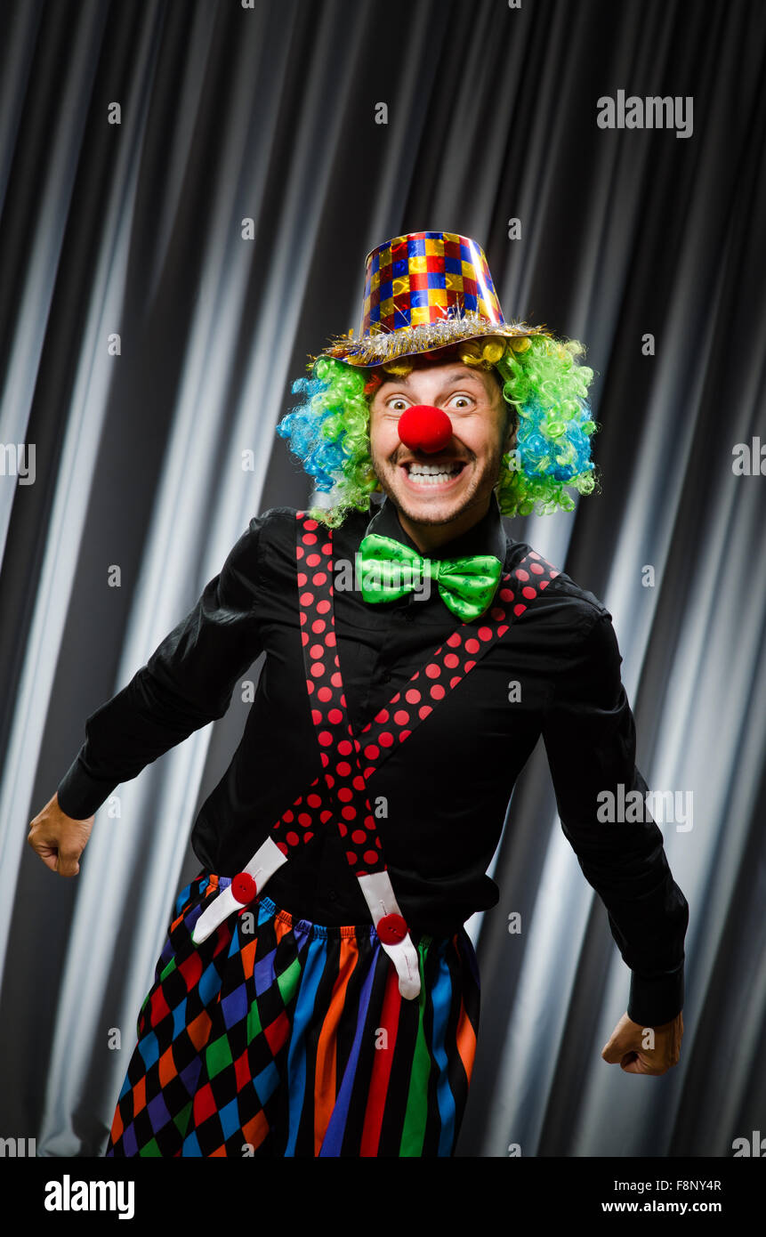 Funny clown in humorous concept against curtain Stock Photo - Alamy