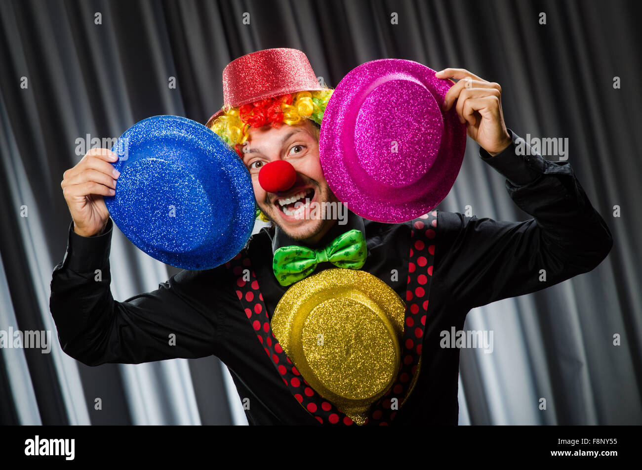 Funny clown in humorous concept against curtain Stock Photo - Alamy