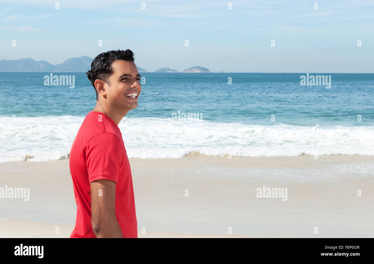 Laughing latin guy walking at beach Stock Photo - Alamy