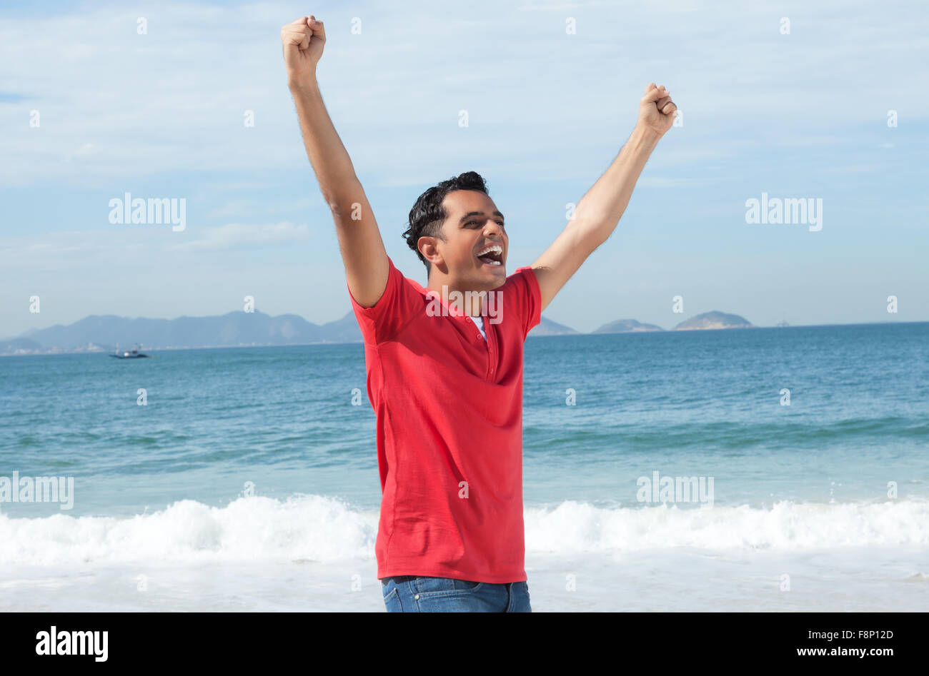 Laughing latin guy cheering at beach Stock Photo - Alamy