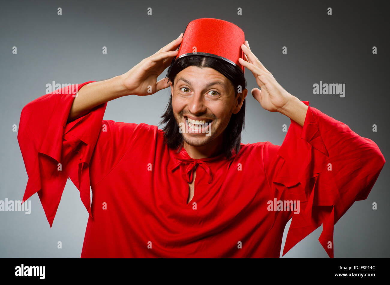 Funny man in red dress wearing fez hat Stock Photo - Alamy